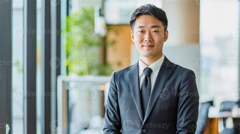 Young Japanese Businessman In Suit In Front Of Blurred Office