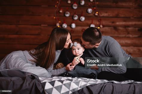 귀여운 젊은 가족 침대에 크리스마스 배경 뒤에 엄마 아빠와 아기 소녀 즐거운 시간을 함께 20 24세에 대한 스톡 사진 및 기타 이미지 Istock