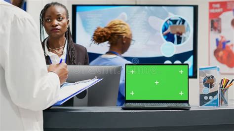 People Working With Greenscreen Display On Laptop In Facility Lobby