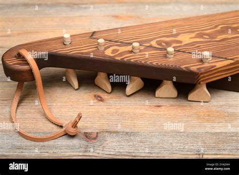 This Image Shows A Close Up Of A Wooden Stringed Musical Instrument Featuring A Rustic