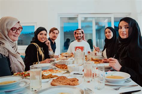 잔치를 깨기 위해 이프타르 저녁 식사를 하는 무슬림 가족 라마단 축제 기간 동안 집에서 전통 음식을 먹습니다 현대 가정에서의 이슬람 할랄 먹고 마시기 Ramadan