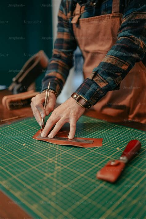 가위로 가죽 조각을 자르는 사람 사진 Unsplash의 가죽 이미지