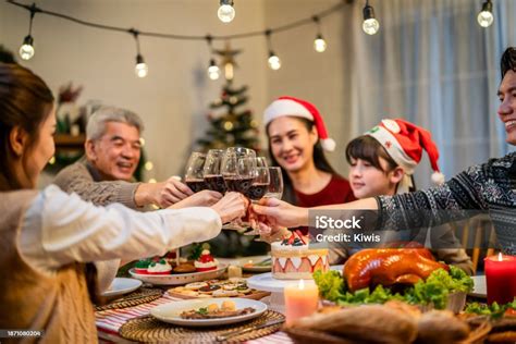 집에서 함께 크리스마스 파티를 축하하는 아시아 사랑스러운 가족 저녁 식사를하는 매력적인 부모와 친척 휴일 추수 감사절 식탁에서 크리스마스 이브를 축하하기 위해 와인 한 잔을