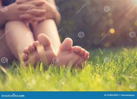 Teenage Girl Sitting Barefoot On Green Grass Outdoors Closeup Space