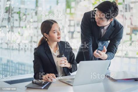 사무실에서 노트북 컴퓨터와 함께 새로운 프로젝트에 협력 하는 두 젊은 아시아 비즈니스 동료 2명에 대한 스톡 사진 및 기타 이미지 Istock