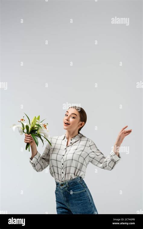 Happy Attractive Girl Posing Like Puppet With Flowers Isolated On Grey