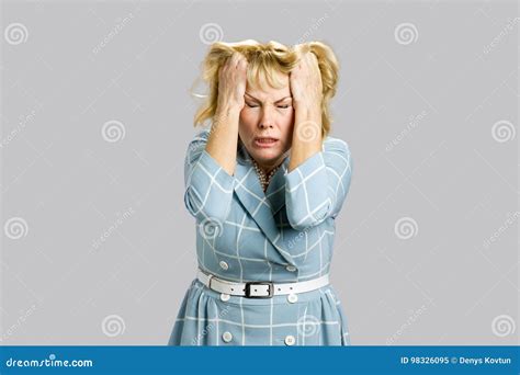 Отчаянная зрелая женщина на серой предпосылке Стоковое Изображение изображение насчитывающей