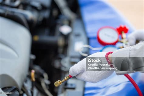 자동차 에어컨 시스템을 점검하고 수리하기 위해 모니터 도구를 들고 수리공 기술자는 자동차 에어컨 시스템 냉매 충전 자동차 에어컨