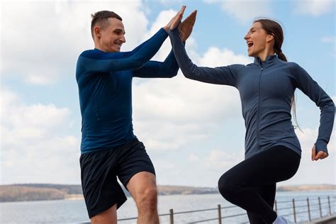 Pareja De ángulo Bajo Haciendo Ejercicios De Entrenamiento Foto Gratis