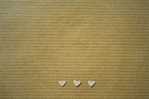 갈색 판지 배경에 세 개의 작은 흰색 하트 사진 Unsplash의 무료 사랑 이미지