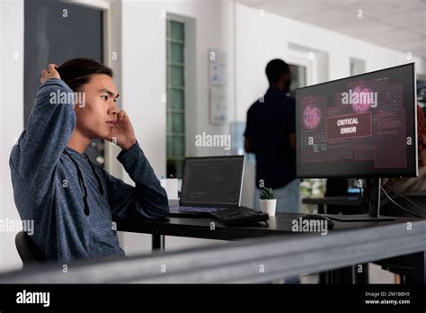 Stressed Asian Web Developer Having Security Breach Alert On Computer