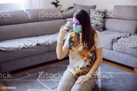 젊은 여성은 보호 마스크와 장갑을 착용 가정 격리에서 온도를 측정합니다 집에 있어 세계 전염병 감염 고온 기침 및 약점의 교향곡