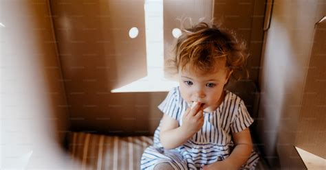 집에 있는 골판지 집에서 실내에서 놀고 간식을 먹는 유아 소녀 사진 Unsplash의 슬로바키아 이미지