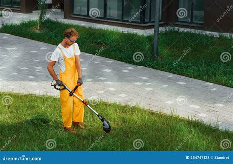 Distant View Man Cut The Grass With Lawn Mover Outdoors In The Yard