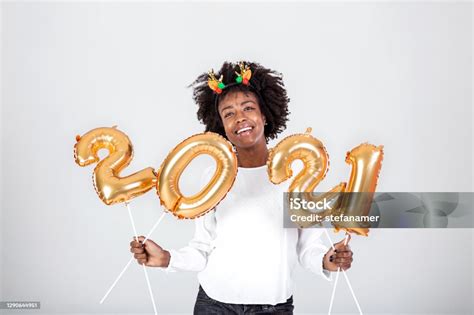 행복한 젊은 아프리카 계 미국인 여자 들고 2021 금 색 풍선 축 하 메리 크리스마스와 화이트 배경에 행복 한 새해 축하 와 휴일 이벤트 개념에 대 한 장식 2021년에