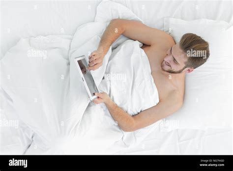Smiling Man Using Digital Tablet Lying On Bed Stock Photo Alamy