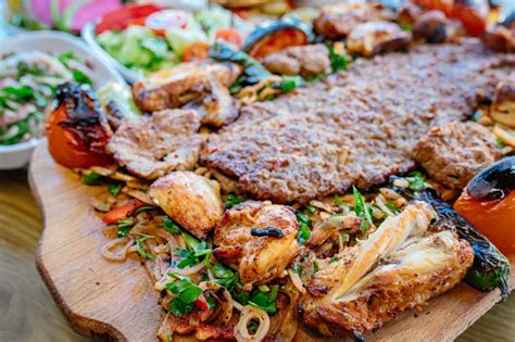 샐러드와 애피타이저를 곁들인 전통 터키식 아다나 케밥 선택적 초점 터키 요리 식사 저녁 식사 테이블입니다 0명에 대한 스톡 사진