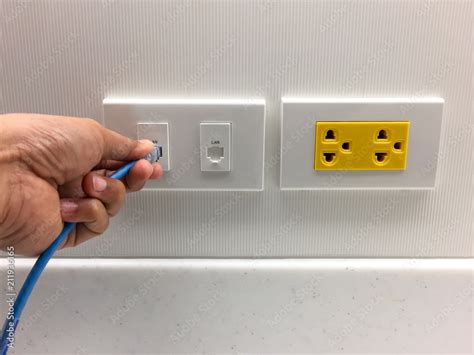Hand Plugs Internet Cable Into WiFi Extender Device Is In Electrical Socket Stock Photo Adobe