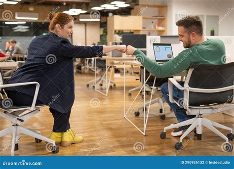Redhead Caucasian Woman And Bearded Man Bumping Fists In Open Space Office Stock Photo Image