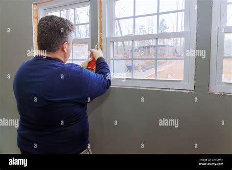 Worker Applies Insulation Sealant Foam To New Window Frame While