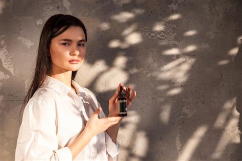 Premium Photo Woman Holding Massage Or Cosmetics Oil Bottle For