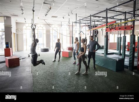 Cross Training Class Watching Instructor Demonstrate Pull Ups On Rings