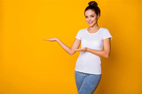 긍정적 인 쾌활한 소녀 프로모터 홀드 핸드의 초상화는 광고 홍보 를 시연해 광택 색상 배경을 통해 고립 된 좋은 모습의 옷을 입고 T 셔츠에 대한 스톡 사진 및 기타 이미지