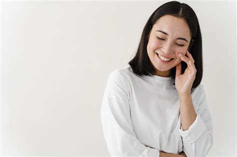 흰색 배경에 아름답게 미소 귀엽고 수줍은 소녀 빈 벽의 배경에 소녀 복사 공간 텍스트 장소 25 29세에 대한 스톡 사진 및 기타 이미지 Istock