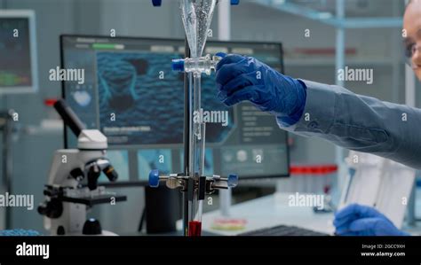 Science Specialist Using Chemical Test Tube In Laboratory On Desk With Research Equipment