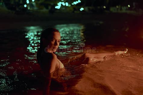 Woman Immersed In Lagoon Waters At Night Radiates Feminine Grace
