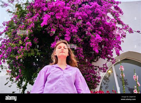 Woman Under The Crown Of A Tree With Purple Flowers Stock Photo Alamy