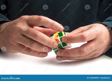 Rubik`s Cube In Hand Of Man On White Table Editorial Stock Image