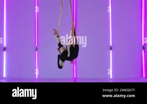 Young Girl Equilibrist In Black Leotard Rotates On Airy Silk And Demonstrates Stretching