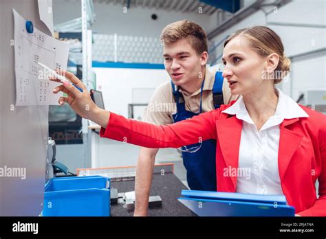 Worker And Manager On Factory Floor Discussing Product Specifications Stock Photo Alamy
