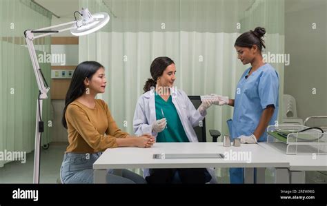 Healthcare Professionals Working Cooperatively Inside A Modern Hospital Room Clad In Medical