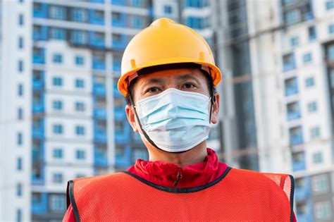 안전 헬멧을 착용한 엔지니어의 위치에 있는 한 남자가 건설 현장에서 작업을 점검하고 있습니다 40 44세에 대한 스톡 사진 및