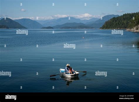 A Grandfather And Granddaughter In A Small Row Boat In A Large Bay
