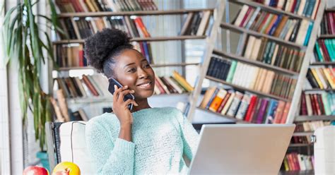 매력적인 젊은 아프리카 여성이 노트북으로 작업하고 집에서 소파에 앉아 웃고 있다 그녀의 스마트 폰에 이야기 하는 아름 다운 여자 사진 Unsplash의 휴대폰 이미지