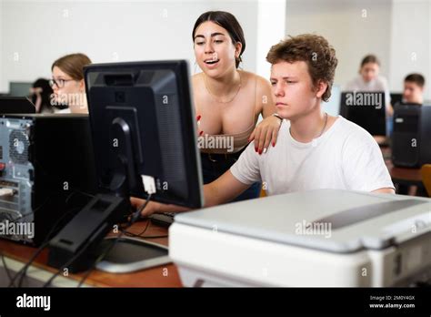 Smiling Female Teenager Helping To The Male Classmate While He Is