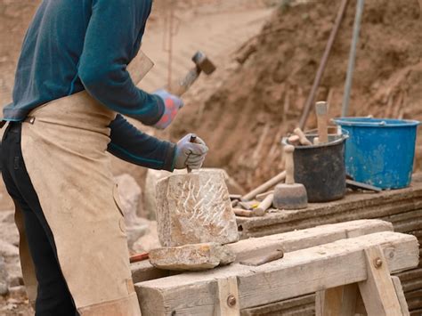 Premium Photo Midsection Of Craftsperson Using Hammer And Chisel On Rock