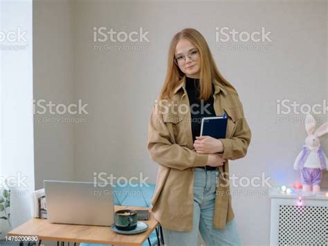 베이지색 블라우스를 입은 젊은 여성이 카페의 테이블 위에 서서 메모장을 들고 있다 먼 일 학생 프리랜서 18 19세에 대한 스톡 사진 및 기타 이미지 Istock