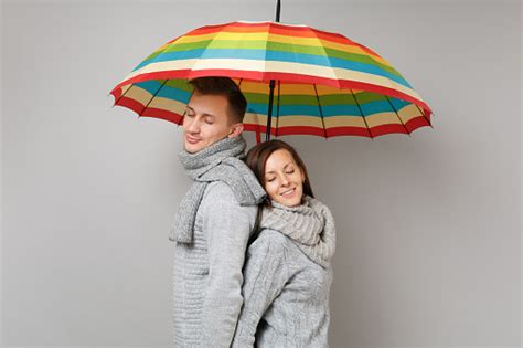 회색 벽 배경 스튜디오 초상화에 고립 된 우산 아래 함께 회색 스웨터 스카프에 커플 여자 사람입니다 건강 한 생활 습관 병 아픈 질병 치료 추운 계절 개념 복사 공간을 모의