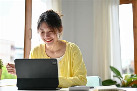 디지털 태블릿을 사용하고 사무실 책상에서 신용 카드를 들고 있는 여성 20 24세에 대한 스톡 사진 및 기타 이미지 20 24세 교환 구매 Istock