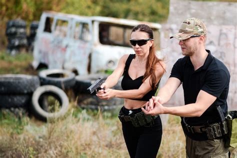 Premium Photo A Weapons Instructor Teaches A Girl To Shoot A Pistol At A Firing Range