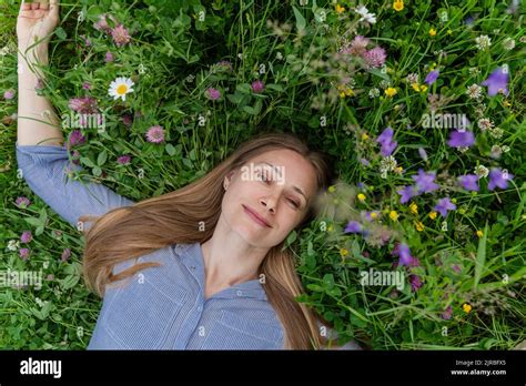 Glückliche reife Frau auf dem Rasen auf dem Feld liegt Stockfotografie Alamy