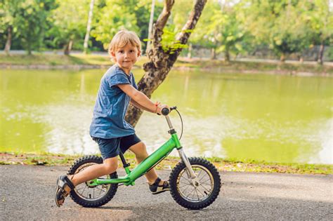 자전거를 타고 있는 어린 소년 진입로에서 움직임에 걸렸습니다 자전거에 미취학 아동의 첫 날 움직임의 기쁨 자전거를 타면서 균형을 유지하는 법을 배운 작은 운동 선수 2 3