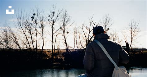 Man Sits On A Dock Facing A Bright Landscape Photo Free Image On Unsplash