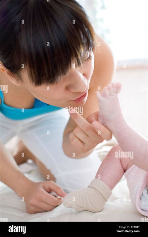 Mother Kissing Baby S Feet Stock Photo Alamy