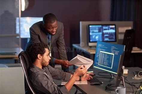 Two Male It Engineers Discussing Documentation At Workplace Stock Image
