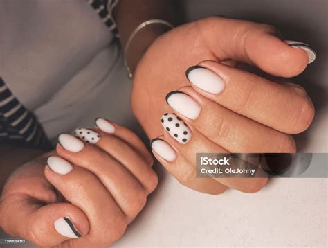 화이트 젤 광택과 블랙 프렌치 디자인의 여성용 손 유백색의 섬세한 색상의 여성용 매니큐어와 얼룩덜룩 한 검은 색 디자인 손톱에 대한 스톡 사진 및 기타 이미지 Istock